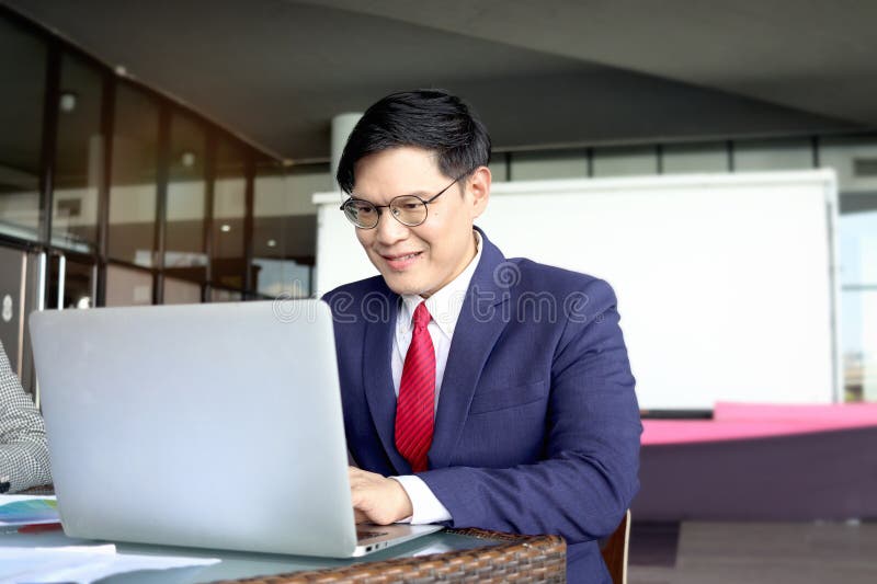 Asian Businessman Manager in Suit Typing on Laptop Computer at Modern ...