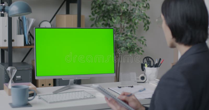 Asian Businessman Writing in Notebook Looking at Computer with Chroma ...