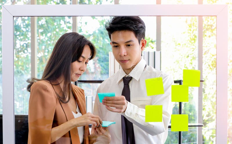 Asian Businessmen and Women Looking and Writing Post-it Notes for ...