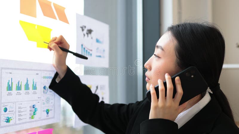 Asian Businesswoman Discussing Data Insights on a Phone Call Stock ...