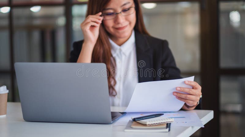 Businesswoman Using and Working on Laptop Computer and Paperwork in ...