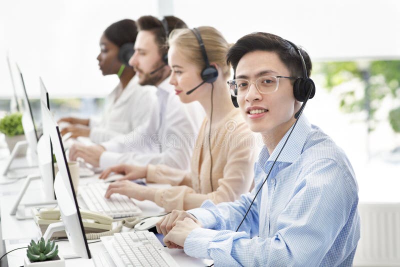 Asian Call Centre Manager Smiling and Looking at Camera in Light Office ...