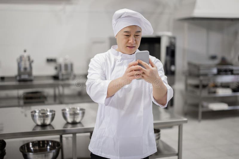 Asian Chef with Phone in the Professional Kitchen Stock Photo - Image ...