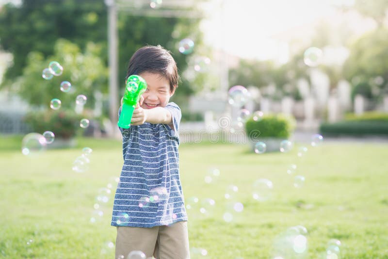 Asian Child Shooting Bubbles from Bubble Gun Stock Photo - Image of ...