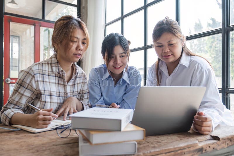 Asian College Groups of Students Using Laptop, Tablet, Studying Together with Notebooks ...