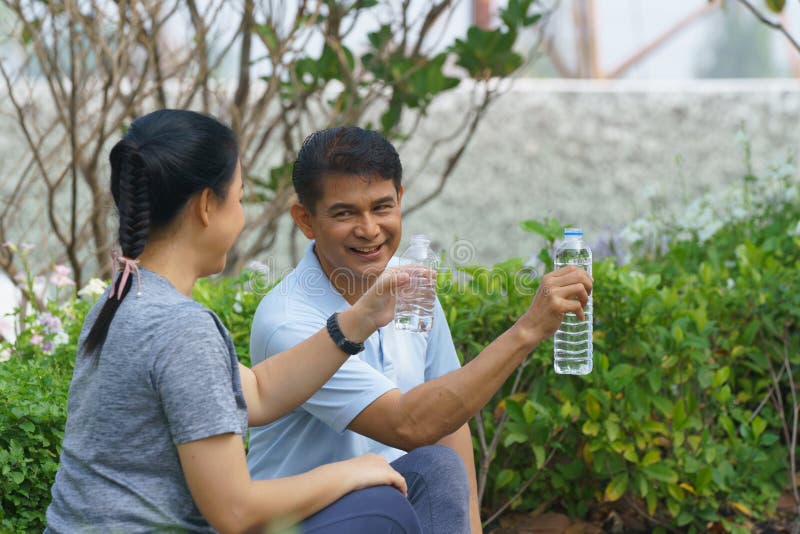 Asian Couple Talking and Drinking Water Together after Exercise ...