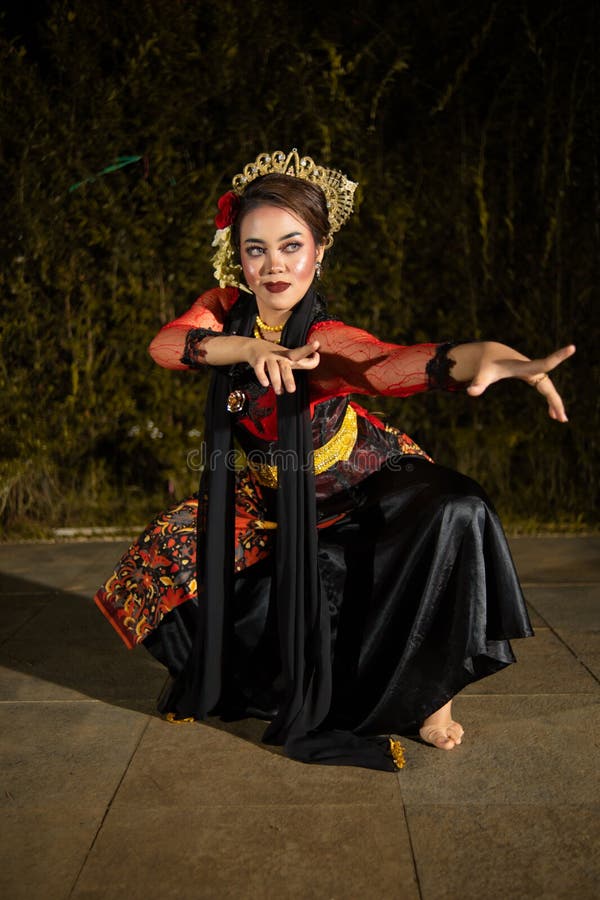 An Asian Dancer in a Red Costume Poses Very Flexibly on a Stage Stock ...
