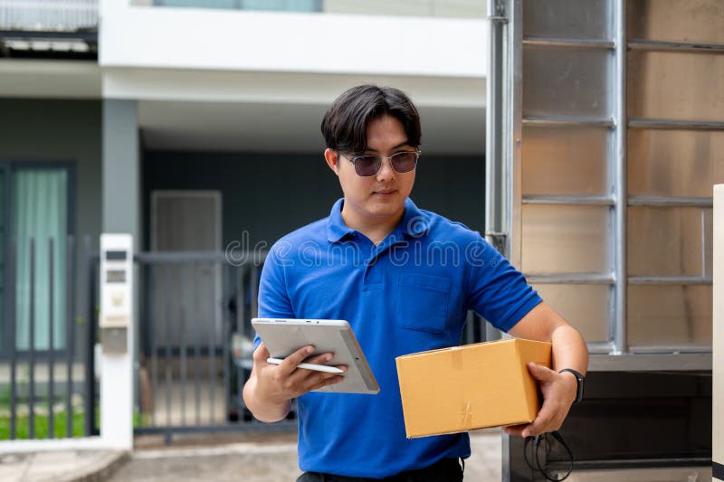 An Asian Delivery Guy Checking the Address on His Tablet while Carrying ...