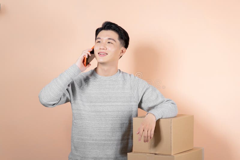 Asian Delivery Man Using Cellphone while Standing with Parcel Boxes ...