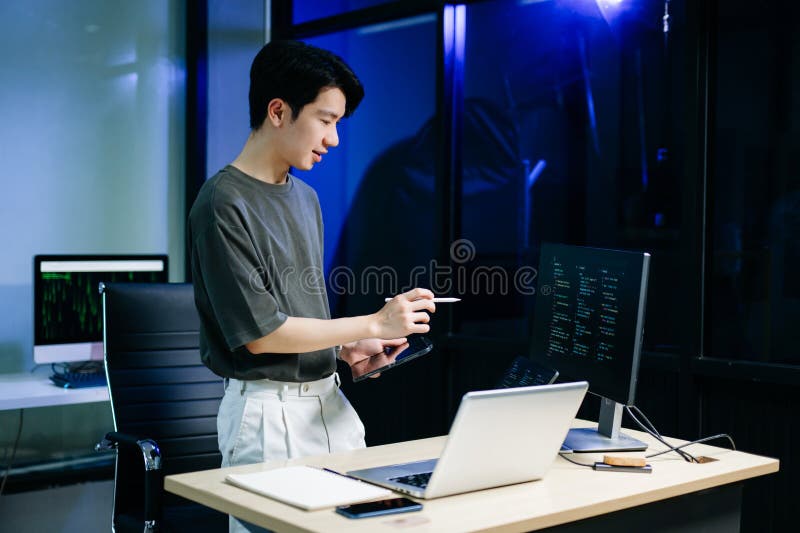 Asian Developer Writing Code at Night in Modern Office Setup. Concept ...