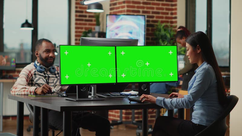 Asian Digital Editor Looking at Greenscreen on Multiple Monitors Stock ...