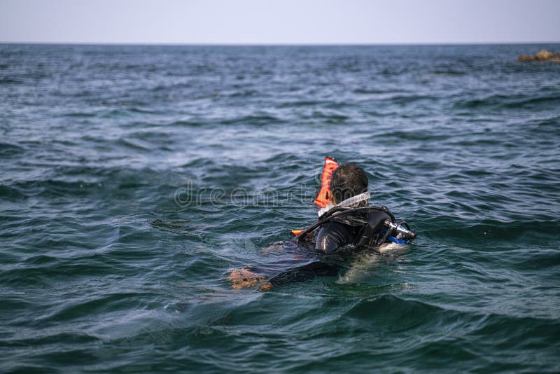 An Asian Diving Man Look Forward To the Coast Line Floating on the Sea ...