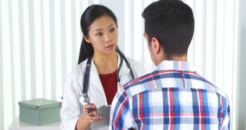 Asian Doctor Asking Patient Questions and Taking Notes Stock Image ...