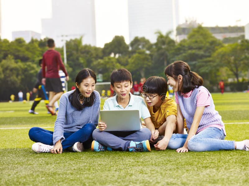 Asian Elementary Schoolchildren Using Laptop Outdoors Stock Photo ...