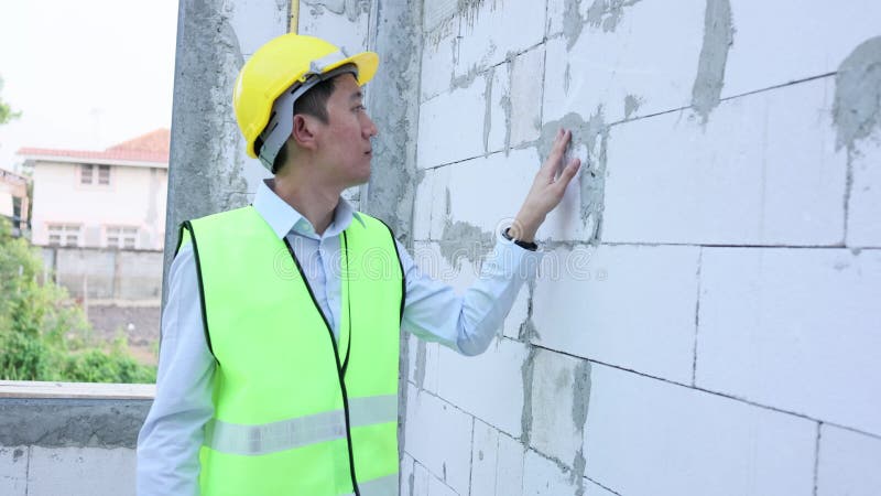 Asian Engineer in Uniform at Construction Site while Checking and ...