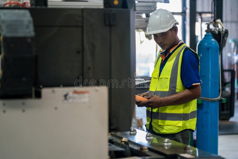Asian Engineer or Worker is Using Remote Control To Control Steel Laser ...