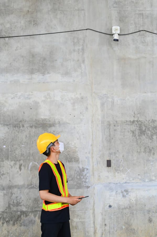 Asian Engineering Worker Wearing Hard Hat and Protective Vest Using ...