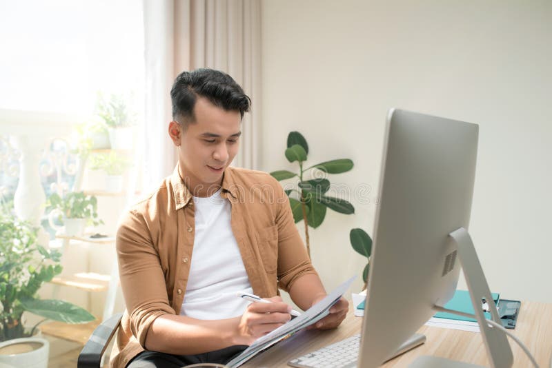 Asian Executive Aged 25-35 at the Desk. he is Thinking of a New ...