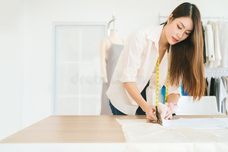 Asian Fashion Designer or Tailor Cutting Fabric with Scissors for ...