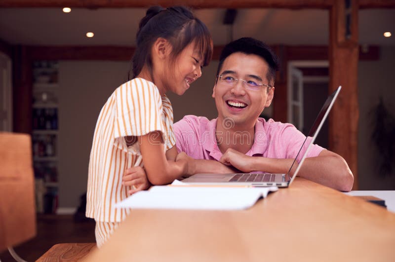 Asian Father Helping Home Schooling Daughter Working at Table in ...