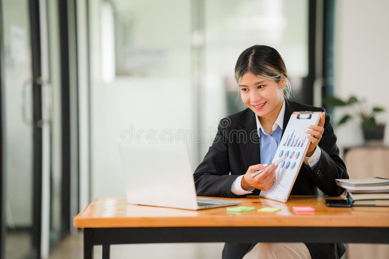 Asian Female Accountant Doing Calculations Analyzing Reports Pointing ...
