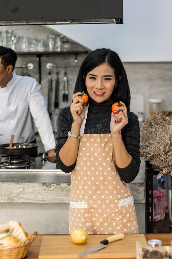 Asian Female Chef is Cooking in the Kitchen. she is Cooking Fried Food ...