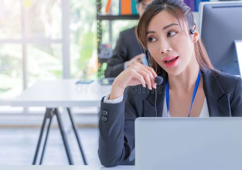 Female Customer Service is Answering Call on Headphone in an Operator ...
