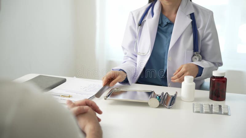 Asian Female Doctor With Male Patient During Consultation In Health