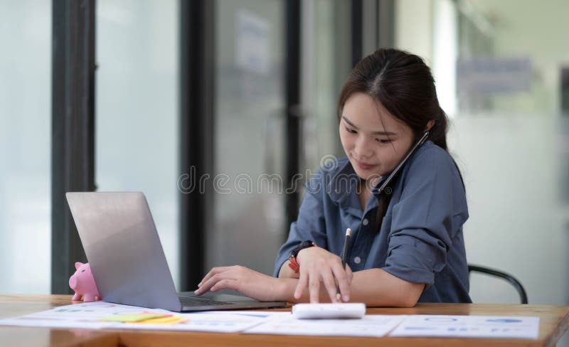 Asian Female Manager Talking on the Phone with a Business Customer ...