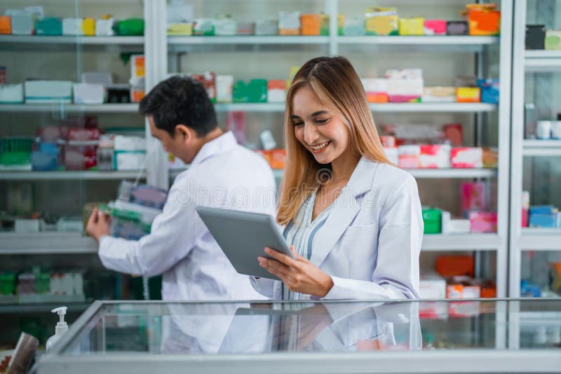 Asian Female Pharmacist in Uniform Working Using Digital Tablet Stock ...