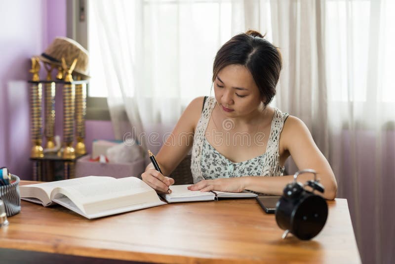 Asian Female Student Take Note after Reading Book on Table Stock Photo ...