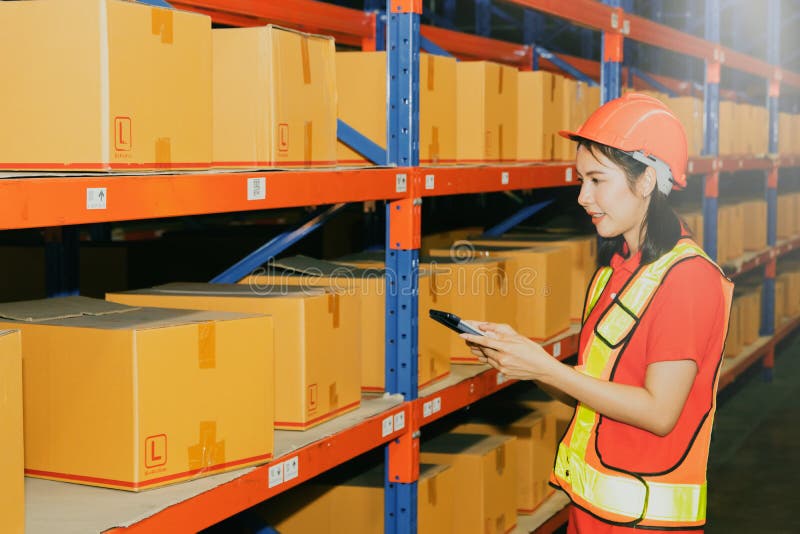 Asian Female Worker Using Tablet To Check Boxes from Warehouse Shelf in ...