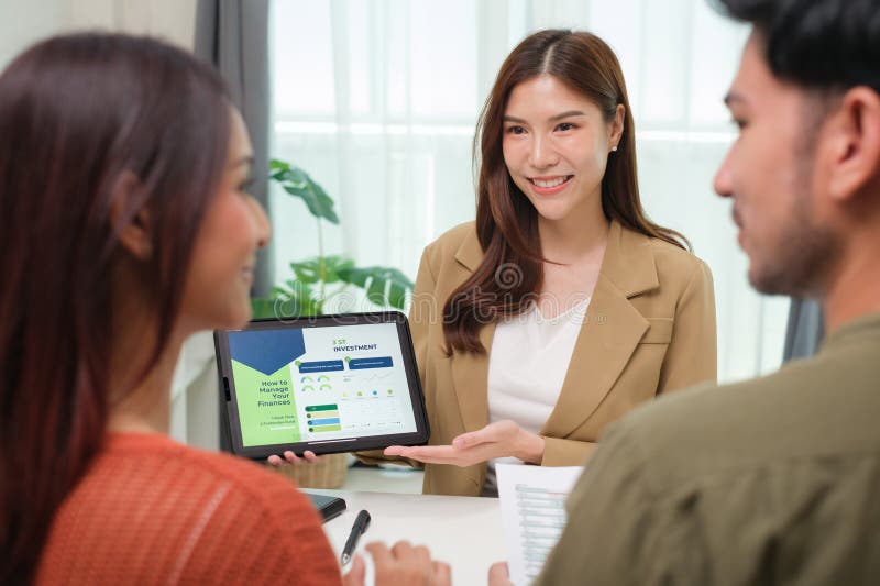 Asian Financial Advisor Presenting Charts and Data on a Tablet during ...