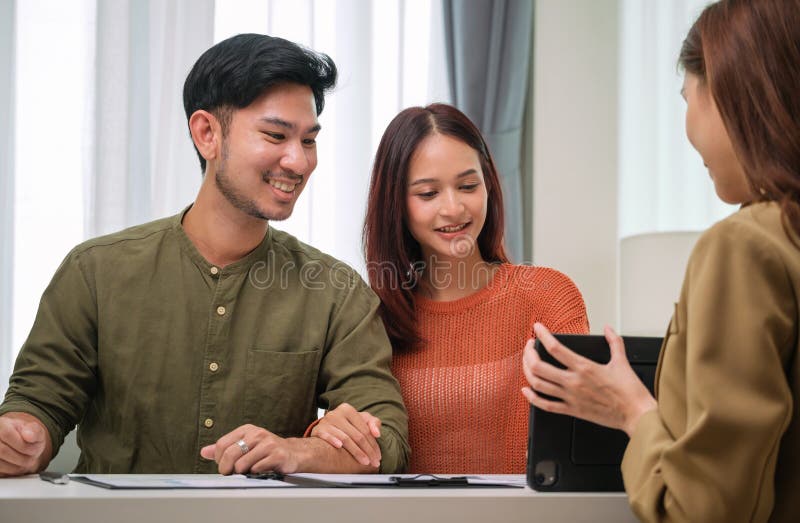 Asian Financial Advisor Presenting Charts and Data on a Tablet during ...