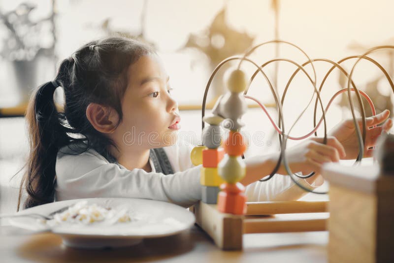 An Asian Girl is Playing Toys while Eating Stock Image - Image of ...
