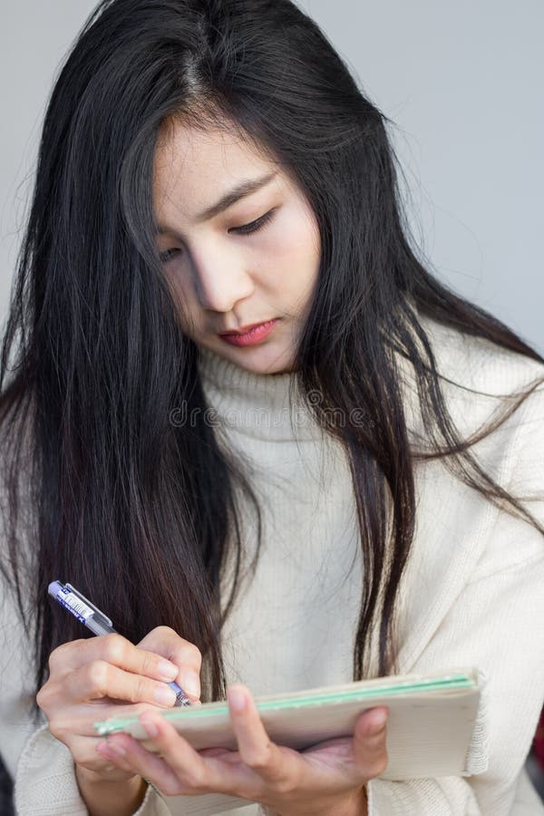 Asian girl taking notes. stock image. Image of holding - 83421211