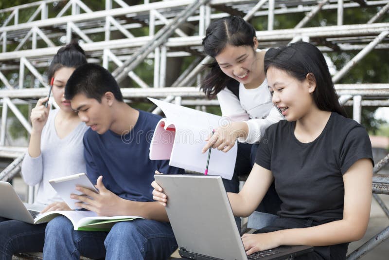 Asian Group of Students Using Tablet and Notebook Sharing with T Stock ...