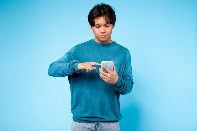 Asian Guy in Blue Sweater Using Cell Phone Stock Image - Image of ...