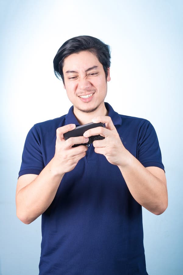 Asian Guy with Mobile Phone in Hand, on Blue Background Stock Photo ...
