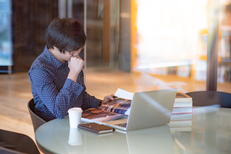 Asian Guy Reading while Working with Laptop Stock Image - Image of ...
