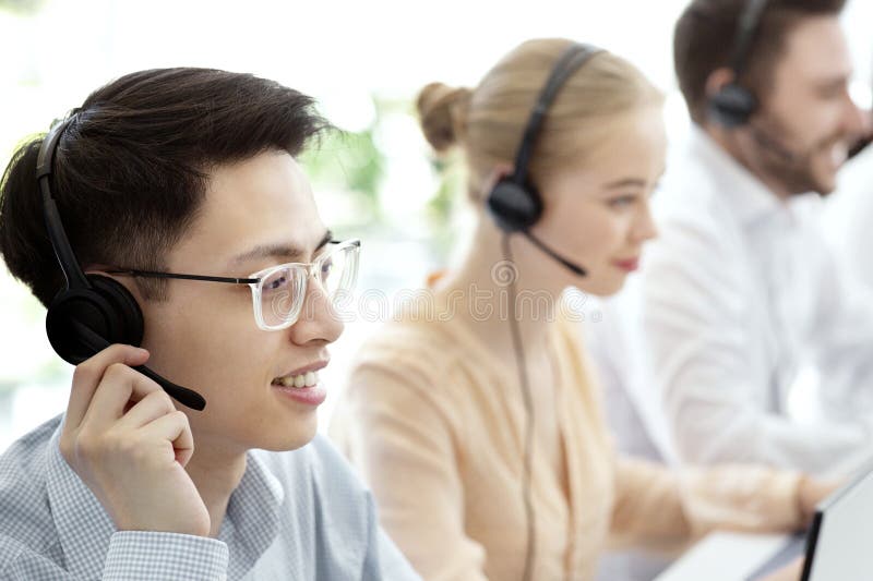 Asian Hotline Operator and His Colleagues Working at Modern Call Centre ...