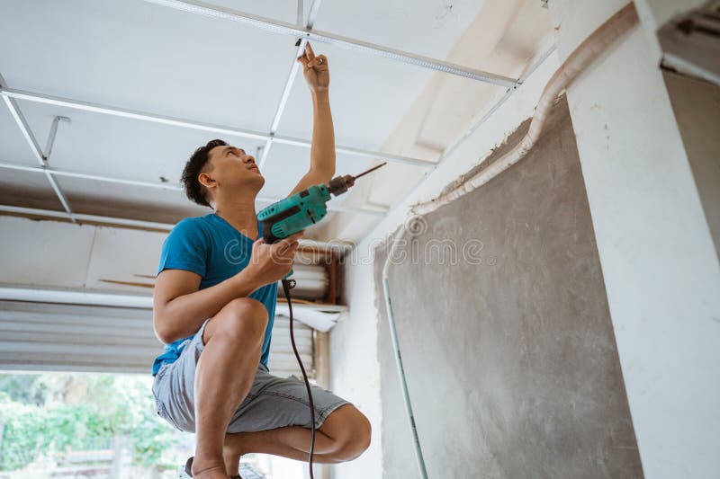 Asian Husband at Work Installing Roof Ceiling Using a Drill Stock Image ...