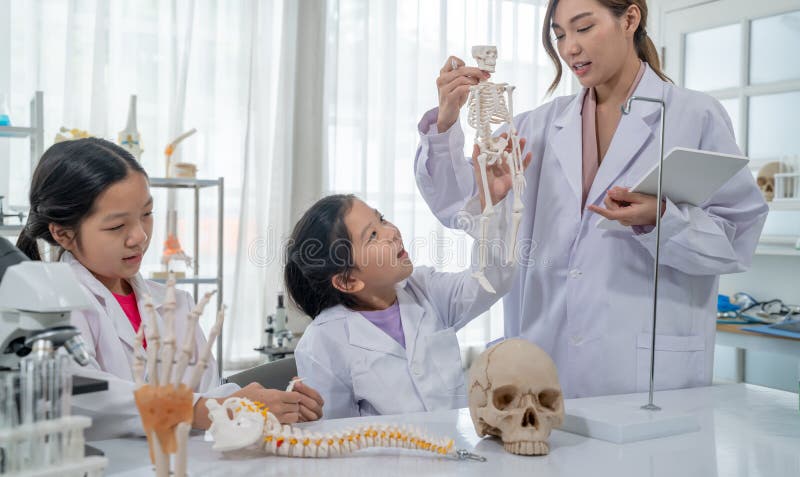 Asian Kid Learning with Doctor in the Laboratory. Physical Examination ...