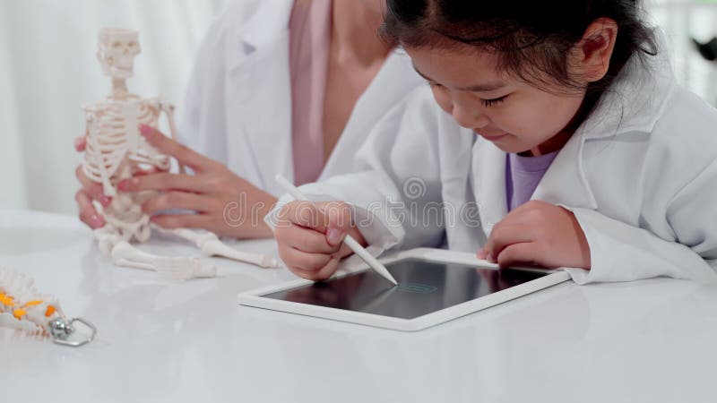 Asian Kid Learning with Doctor in the Laboratory. Physical Examination ...