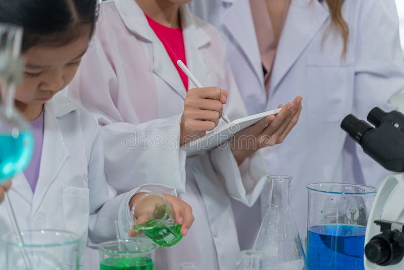 Asian Kid Learning with Scientist in the Laboratory. Physical ...