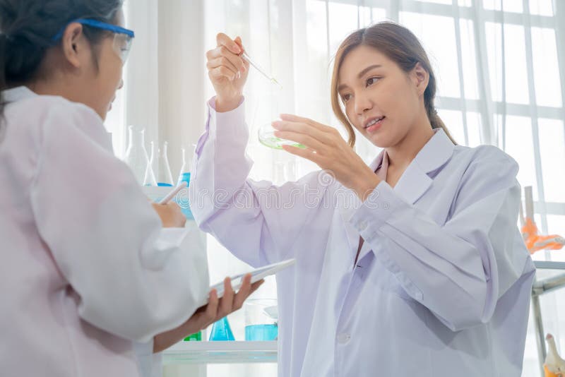 Asian Kid Learning with Scientist in the Laboratory. Physical ...