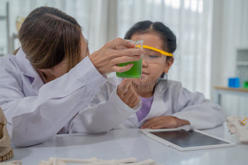 Asian Kid Learning with Scientist in the Laboratory. Physical ...