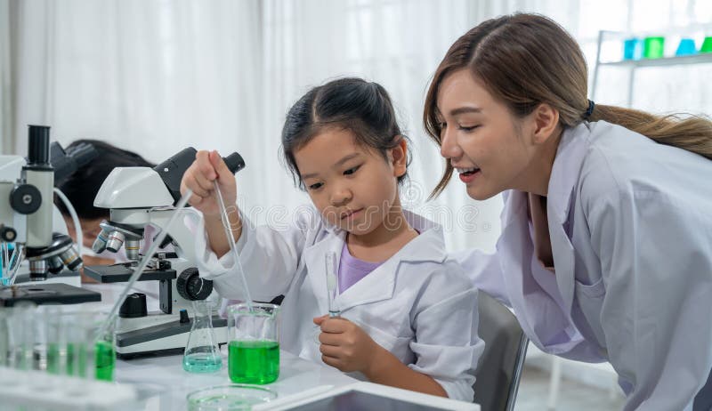 Asian Kid Learning with Scientist in the Laboratory. Physical ...