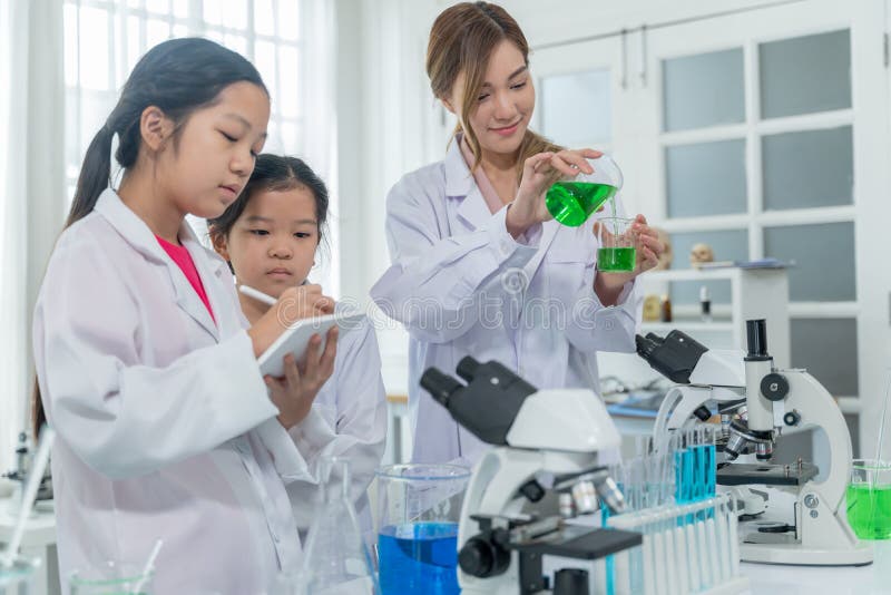 Asian Kid Learning with Scientist in the Laboratory. Physical ...