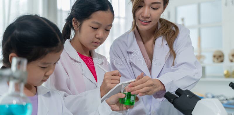Asian Kid Learning with Scientist in the Laboratory. Physical ...